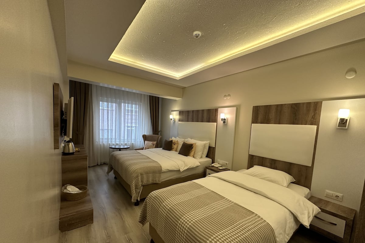 Quarto Triplo Familiar, várias camas, não fumadores, Vista para a cidade | Roupa de alta qualidade, minibar, secretária