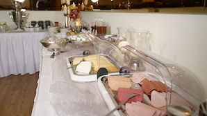 Disposição de buffet com diversos alimentos e acompanhamentos.