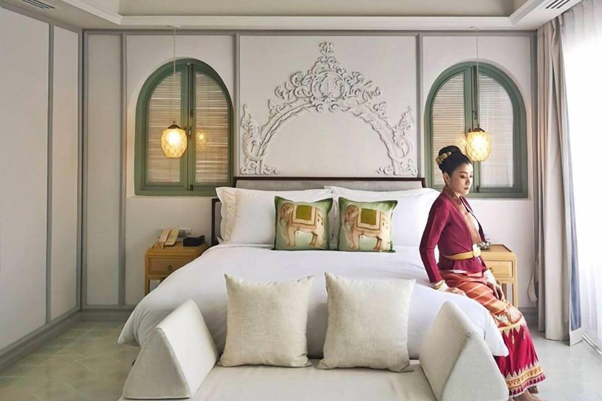 Um quarto espaçoso com uma cama grande, duas mesas de cabeceira e um ventilador de teto decorativo.