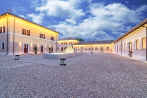 Pátio com chão de cascalho, cercado por edifícios com arquitetura uniforme e várias janelas.