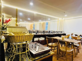 Disposição de buffet com cestos de vime, uma faca em tábua de corte e diversos recipientes com alimentos.