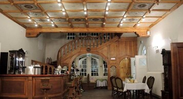 Um quarto amplo com escada de madeira, área de jantar e um bar.