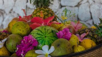 Uma cesta com frutas e flores diversas.