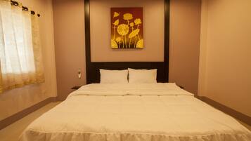 Cama bem arrumada com lençóis brancos, cabeceira e uma obra de arte na parede com flores amarelas.