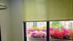 Casa de banho com sanita, lavatório e janela com caixas de flores.