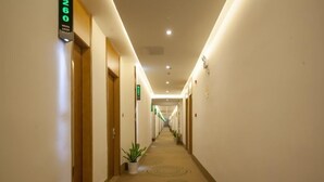 Um corredor de hotel com portas em ambos os lados, um carpete com padrões circulares e uma placa indicando o quarto número 260.