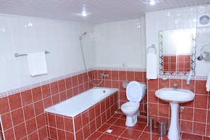 Casa de banho com banheira, sanita e lavatório.