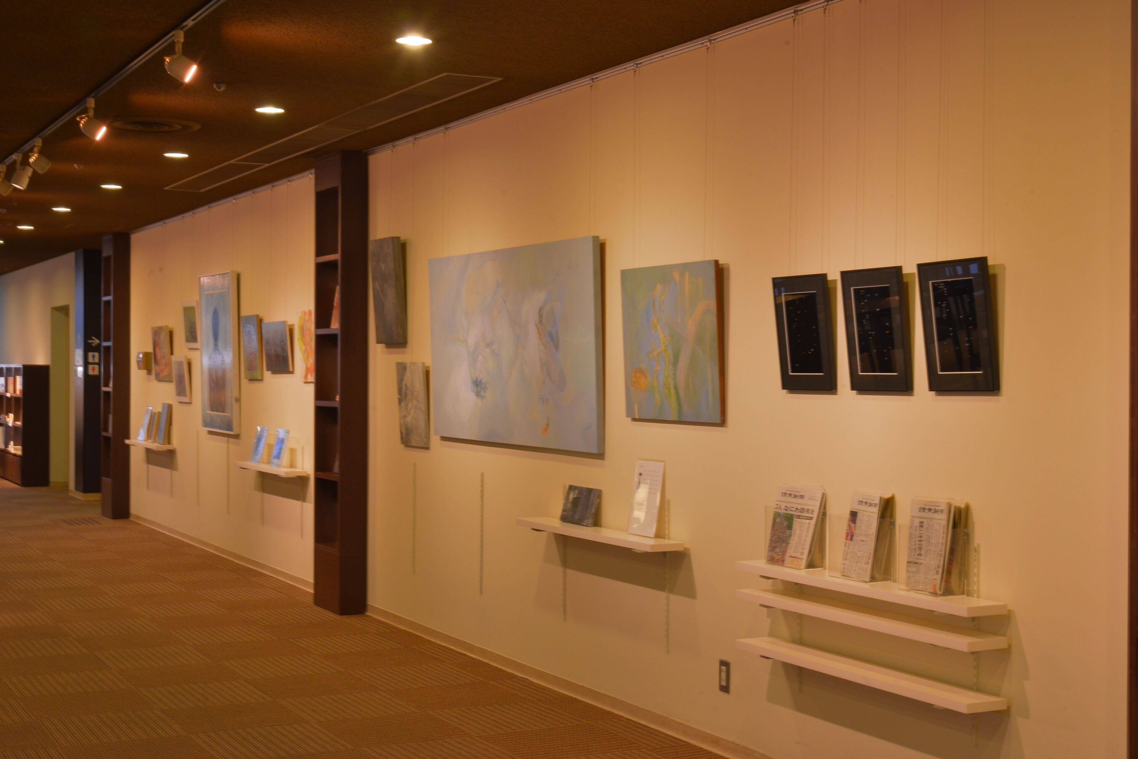 Uma galeria com obras de arte expostas nas paredes e prateleiras.