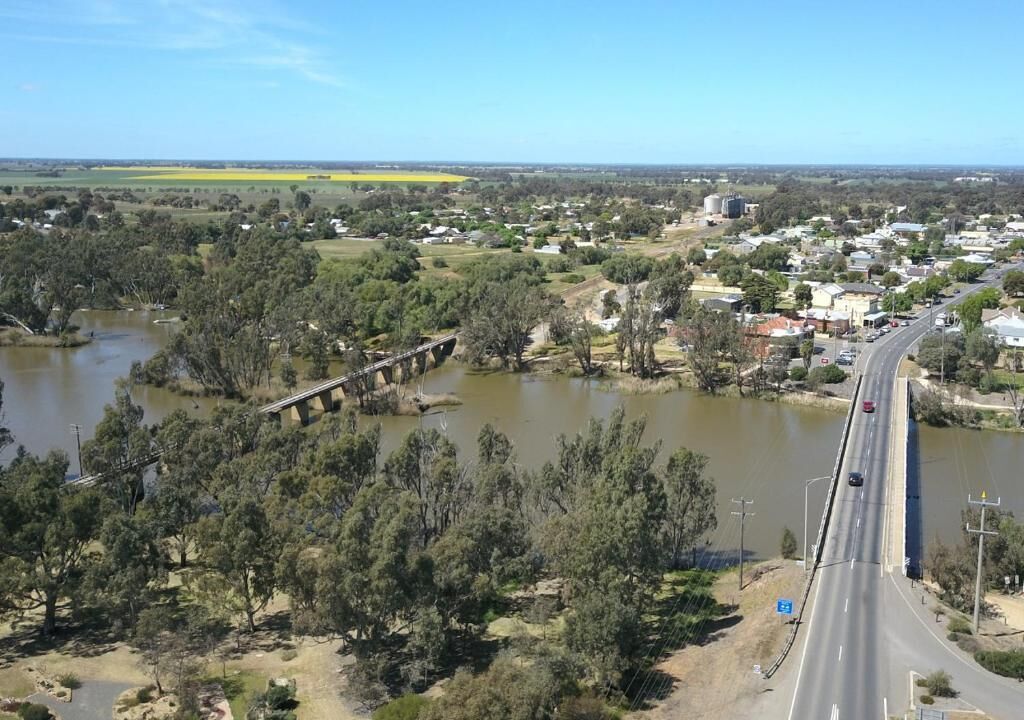 Uma ponte sobre um rio, com uma cidade ao fundo.