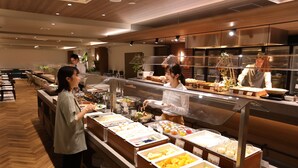 Uma área de buffet com diversas opções de comida e um espaço de refeições com mesas e cadeiras.