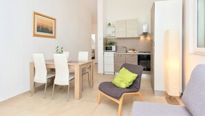 Um espaço compacto com área de refeições, kitchenette e espaço para sentar.