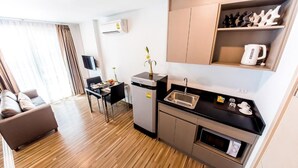 Quarto de hotel compacto com cozinha compacta, espaço para refeições e área de estar.