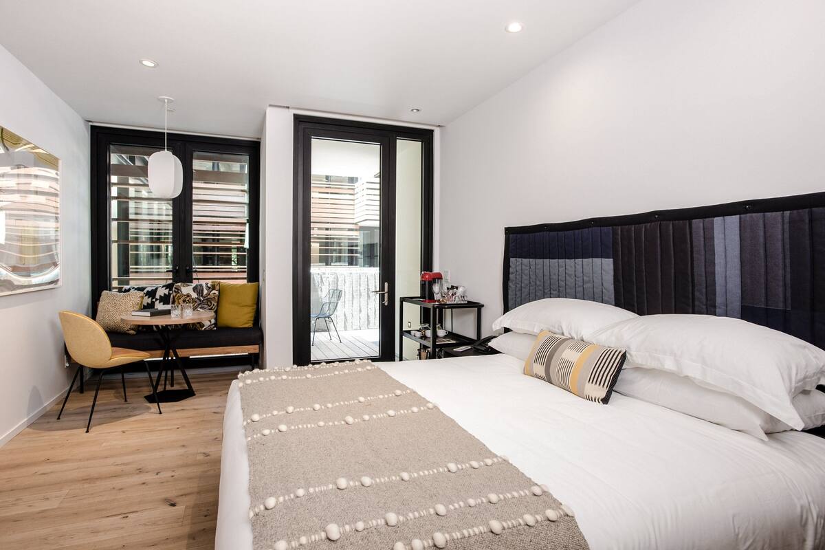 Quarto moderno com uma cama grande, uma escrivaninha e uma cadeira.