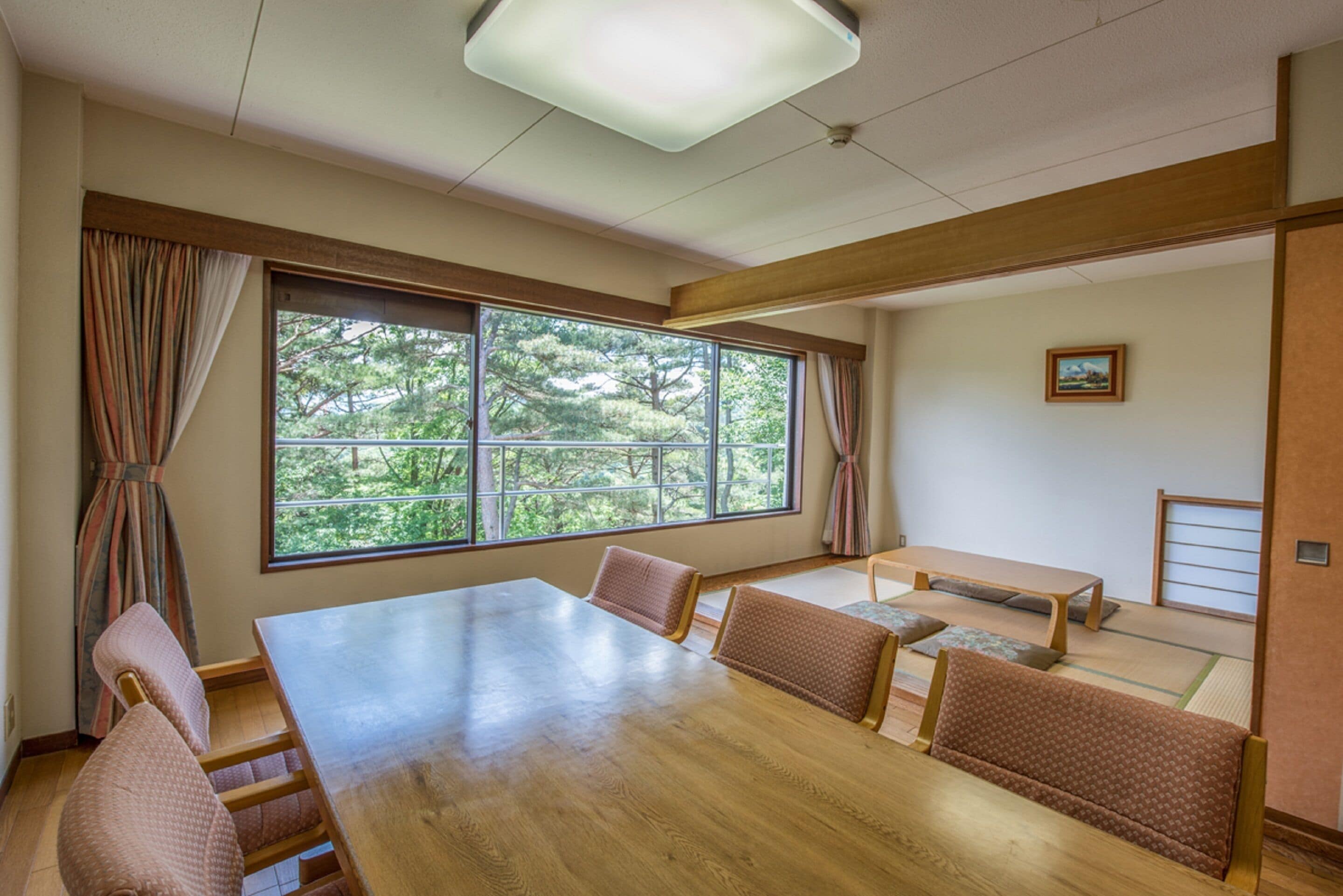 Um quarto em estilo japonês tradicional, com esteiras de tatame, uma mesa de madeira e almofadas.