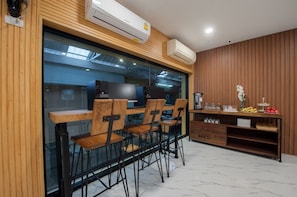 Uma cozinha moderna com armários de madeira, bancada de mármore e área de jantar com mesa e cadeiras de madeira.