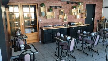 Restaurante com paredes de tijolo, mesas de madeira e cadeiras pretas.