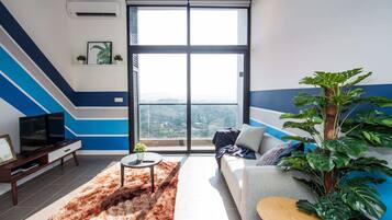 Uma sala de estar moderna com uma janela grande, um sofá, uma mesa de centro e uma televisão.