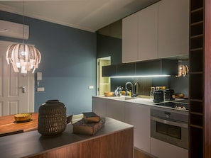 Cozinha moderna com forno embutido, pia e bancada com objetos decorativos.