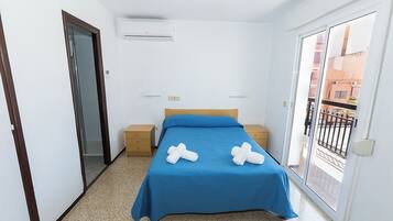 Quarto com uma cama, duas mesas de cabeceira, uma janela e um ar condicionado.