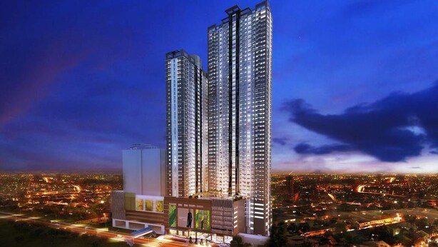 Um edifício alto com vários andares, cercado por uma paisagem urbana noturna.