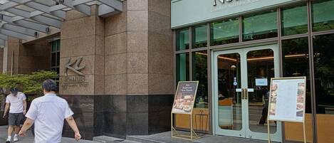 Exterior do Nono's Comfort Kitchen & Bakery, com fachada de pedra e grandes janelas de vidro.