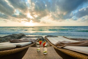 Na praia, espreguiçadeiras, guarda-sóis de praia, toalhas de praia 