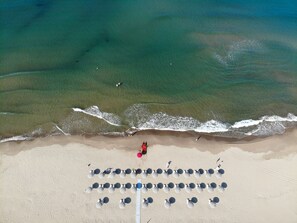 Uma praia privada, espreguiçadeiras, guarda-sóis de praia 