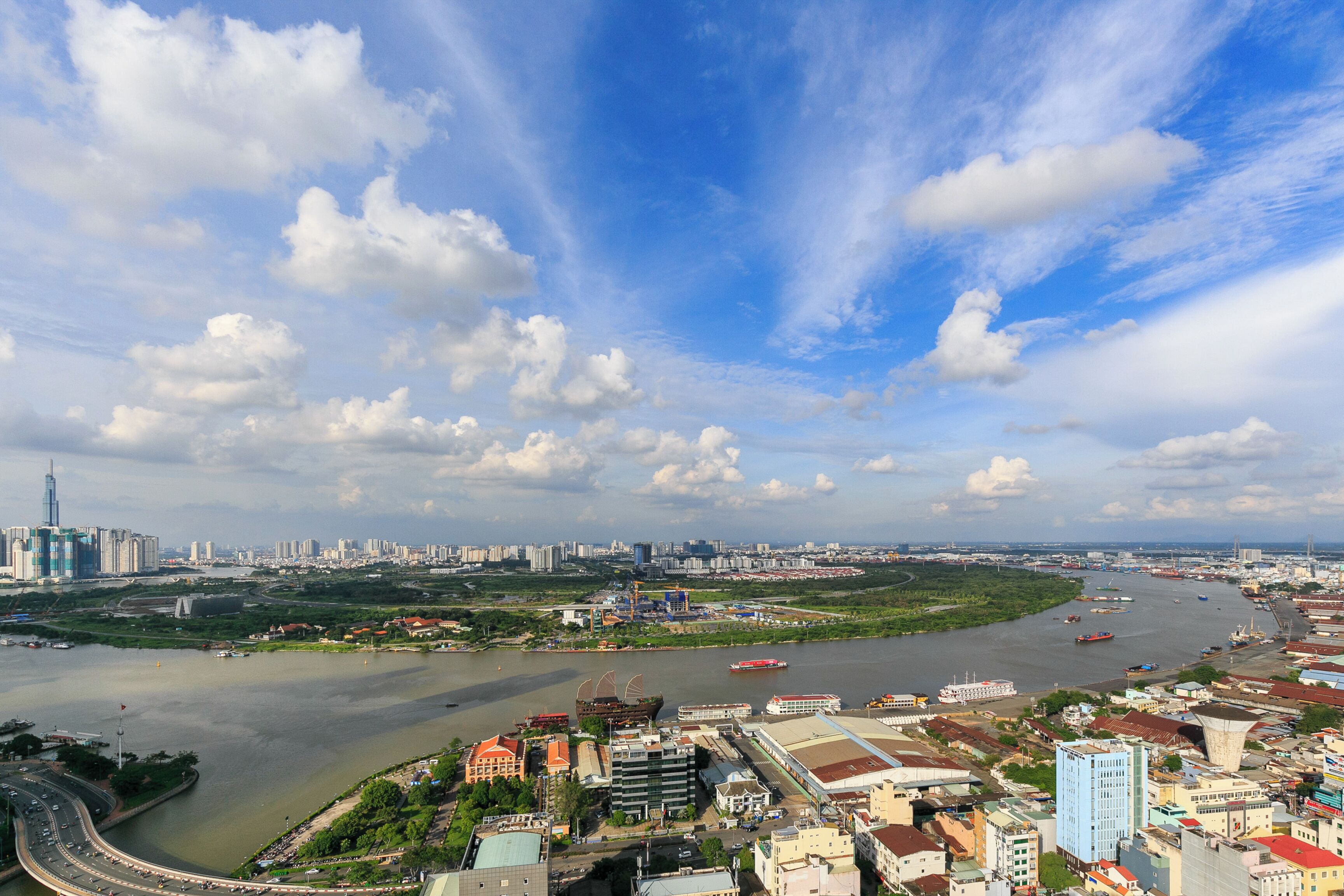 Vista panorâmica de uma cidade com rio, edifícios e uma ponte.