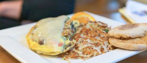 Um prato com omelete, hash browns e torradas.