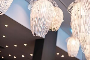 Um interior moderno com luminárias pendentes e iluminação embutida no teto.