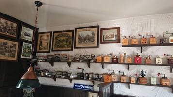 Quarto com eletrodomésticos antigos e quadros em molduras antigas nas paredes.
