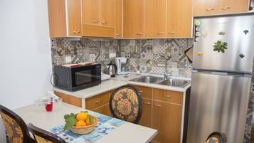 Apartamento luxo, 1 quarto, terraço, vista para o mar | Cozinha americana privada | Geladeira, micro-ondas, cooktop, cafeteira/chaleira