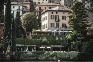 Um hotel à beira-mar com área externa para sentar e um jardim.