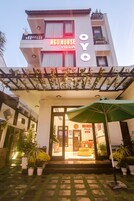Entrada de hotel com uma placa indicando 'NGO HOUSE VILLA OYO'.
