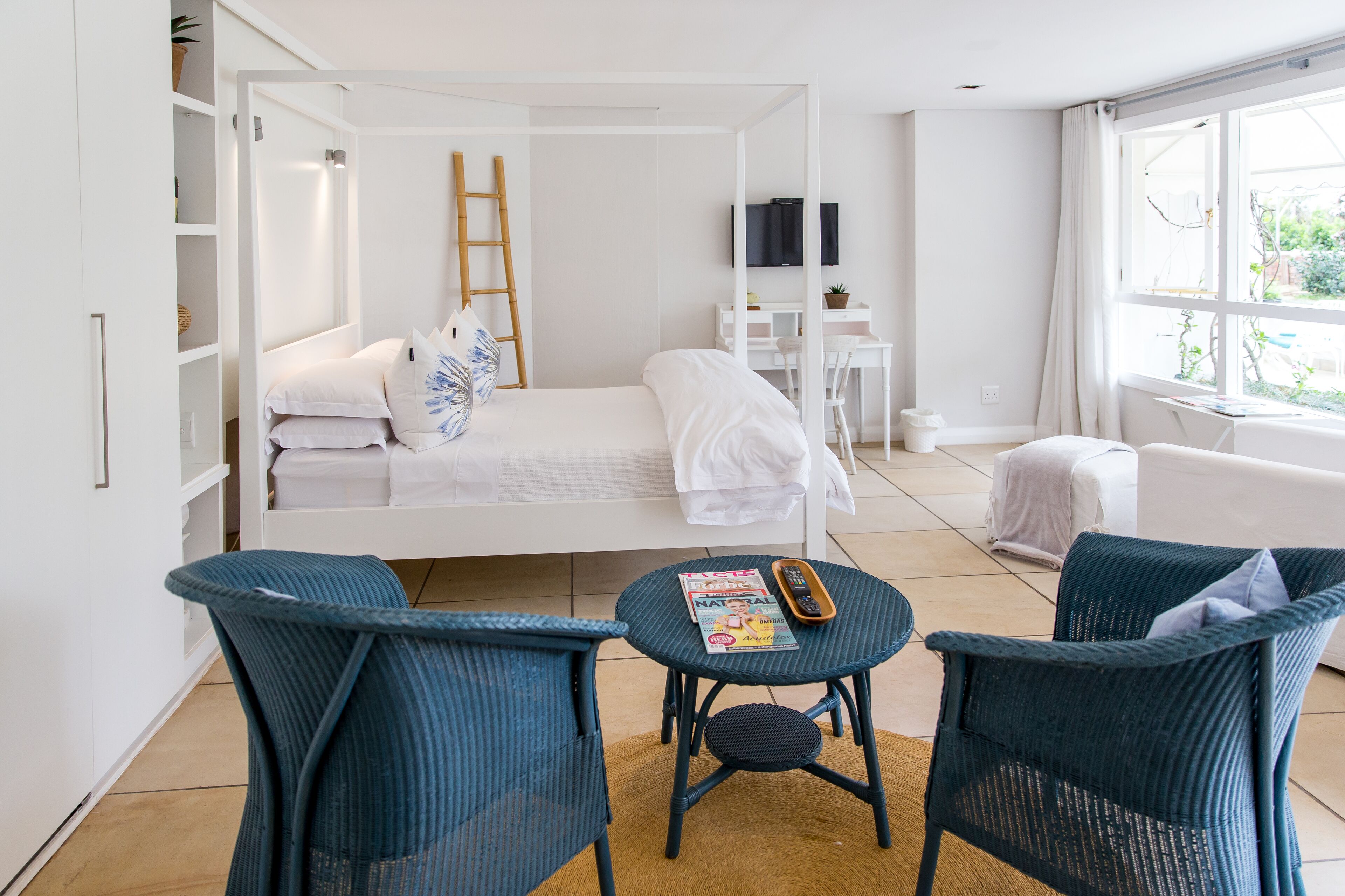 Quarto moderno com uma cama, uma escrivaninha e duas cadeiras.