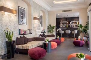 Uma área de estar moderna, com assentos, um bar e uma estante de livros.