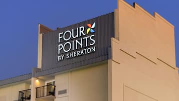 Um letreiro de hotel com o nome "FOUR POINTS BY SHERATON" e um logotipo colorido.