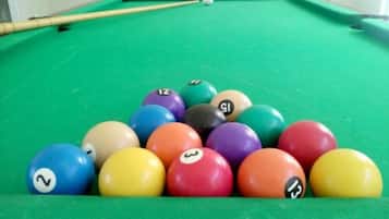 Uma mesa de sinuca com um conjunto de bolas coloridas dispostas em formação triangular.