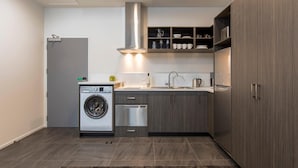 Uma cozinha moderna com eletrodomésticos embutidos, armários de madeira e uma porta cinza.