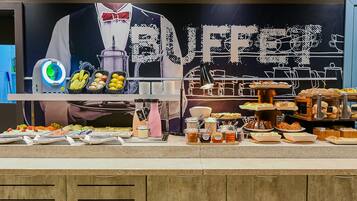 Disposição de buffet com diversos alimentos e um grande letreiro escrito 'BUFFET'.