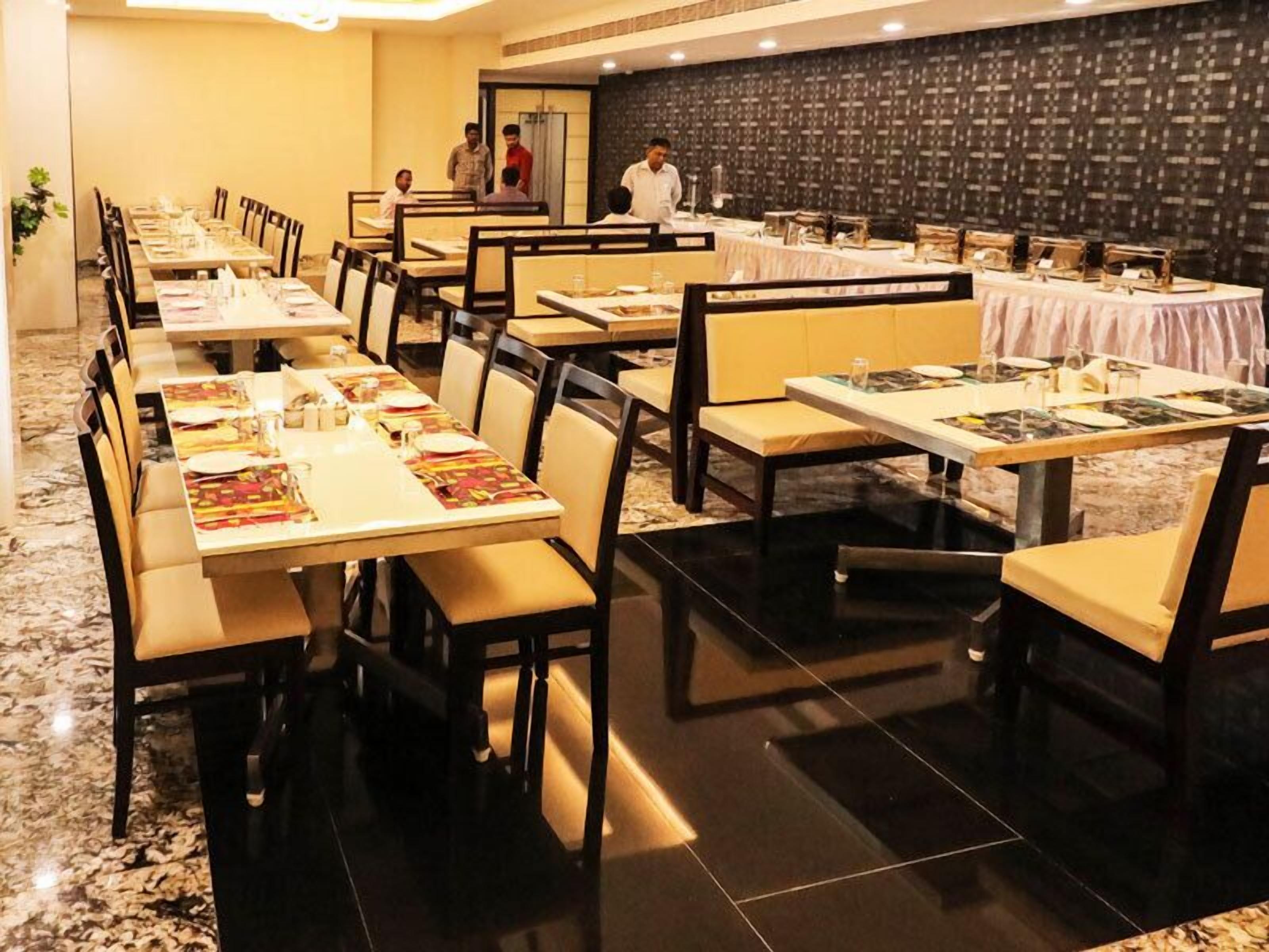 Um restaurante com várias mesas e cabines, dispostas num espaço amplo com chão em azulejos.