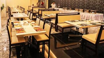 Um restaurante com várias mesas e cabines, dispostas num espaço amplo com chão em azulejos.