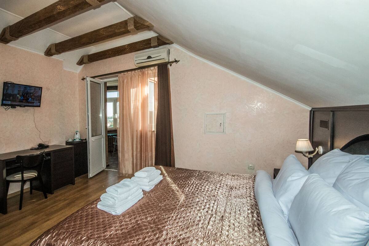 Quarto com cama, escrivaninha e cadeira.