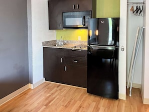 Um frigorífico/congelador grande, um micro-ondas, uma cafeteira/bule 