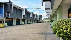 Fileira de quartos de hotel com um caminho de concreto entre eles.