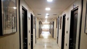 Um corredor comprido e estreito, com portas de ambos os lados, que dá acesso a quartos individuais.