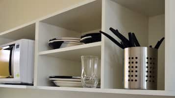 Um frigorífico, um micro-ondas, utensílios de cozinha