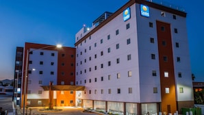 Um hotel de vários andares com um destaque para a placa Comfort Inn, uma entrada coberta e fachada bem iluminada.