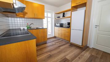 Apartamento Comfort, 2 quartos | Cozinha privada | Um frigorífico, uma placa de cozinha, uma chaleira elétrica