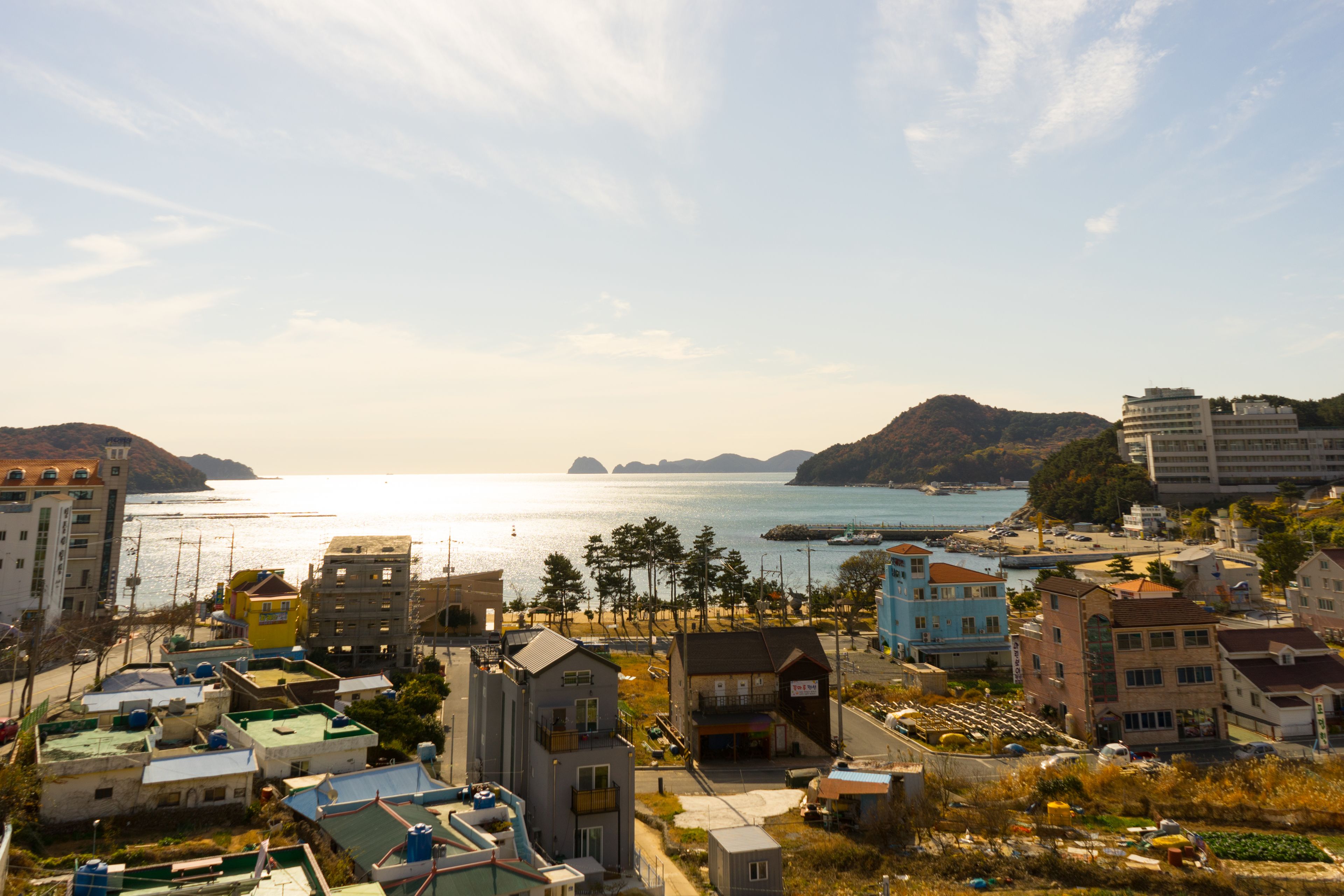 Uma cidade costeira com edifícios, uma praia e vista para o mar.